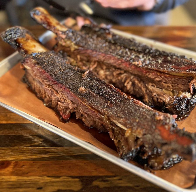 These beef ribs aren't just dinner – they're prehistoric monuments to smoking expertise, with a bark so perfect it deserves its own appreciation society.