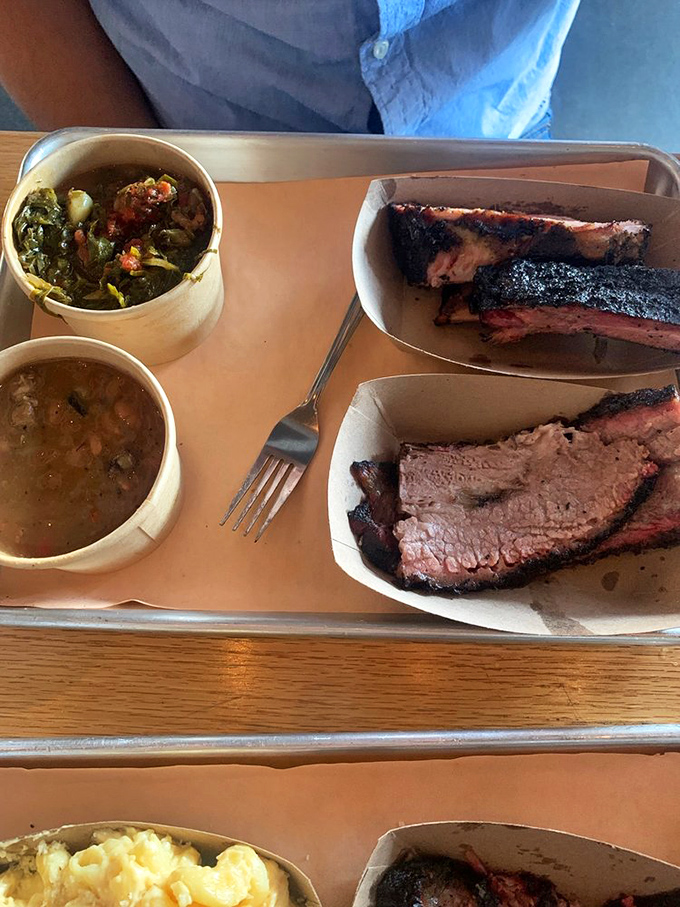 A tray of smoky treasures alongside collard greens and beans. This isn't just lunch&mdash;it's a Southern revival meeting on a plate.