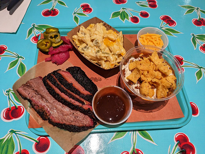 A tray of happiness: slices of brisket with that glistening bark, mac and cheese, and pickled accoutrements to cut through the richness.