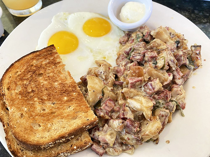 This isn't just corned beef hash; it's a masterclass in breakfast architecture with perfectly sunny eggs standing guard over savory treasures below