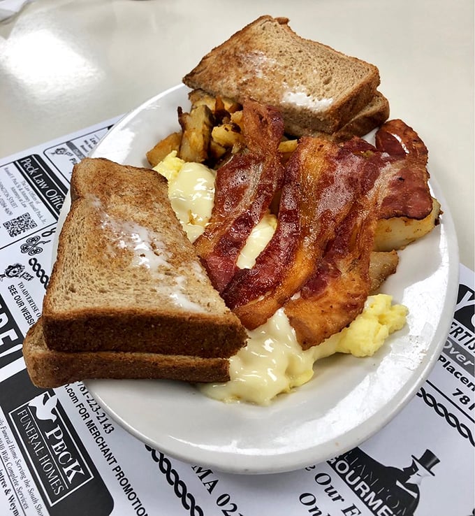 The breakfast trinity: golden toast buttered to the edges, bacon cooked to that perfect crispy-yet-chewy sweet spot, and eggs that practically sunshine off the plate.