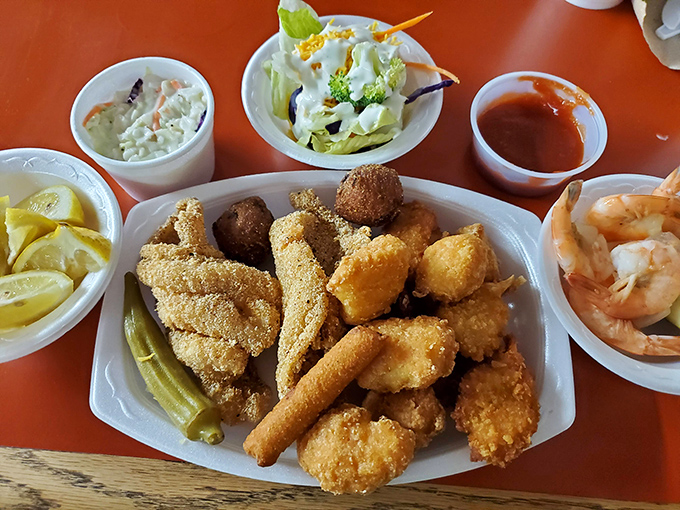 A feast fit for Neptune himself: golden catfish, succulent shrimp, and all the fixings arranged in perfect harmony on a humble paper plate.
