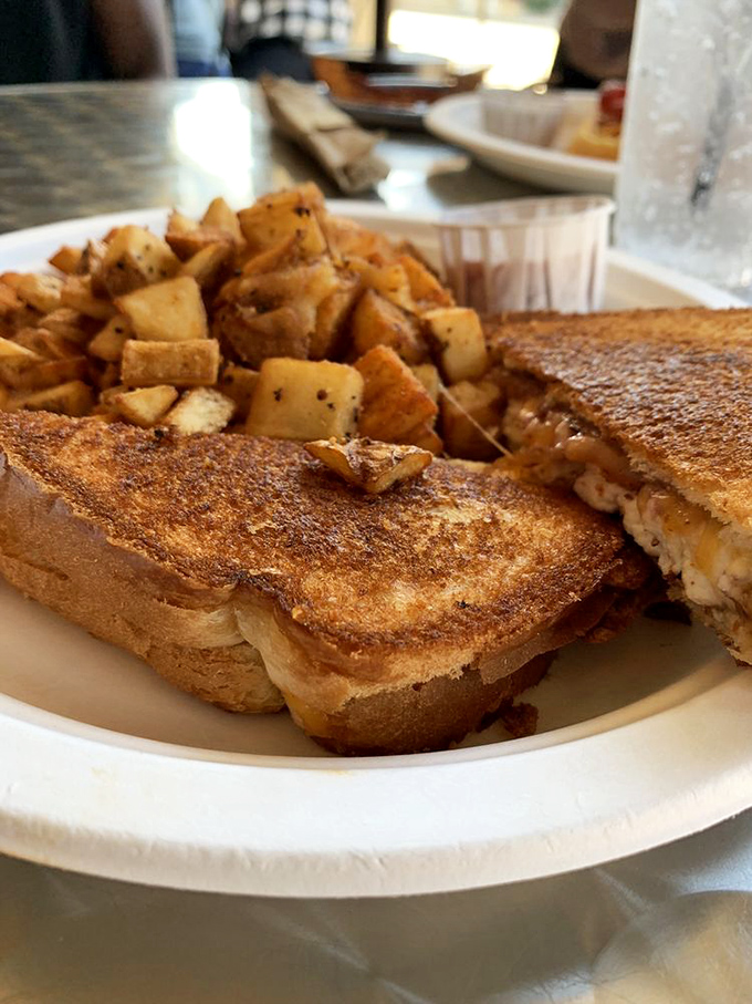 The humble grilled cheese gets its glamour shot moment, golden-brown and ready for its close-up, with home fries playing the perfect supporting role.