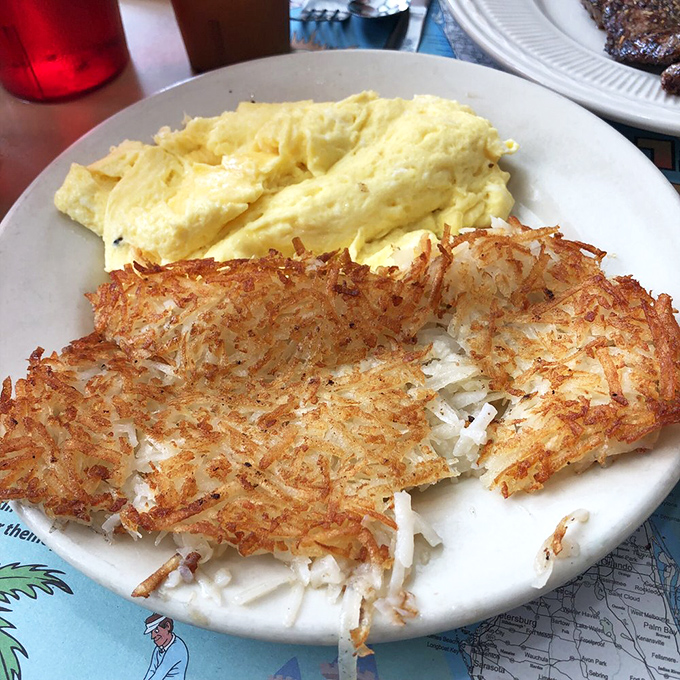 The breakfast power couple: fluffy scrambled eggs alongside hash browns with that magical crisp-tender balance that haunts your breakfast dreams.