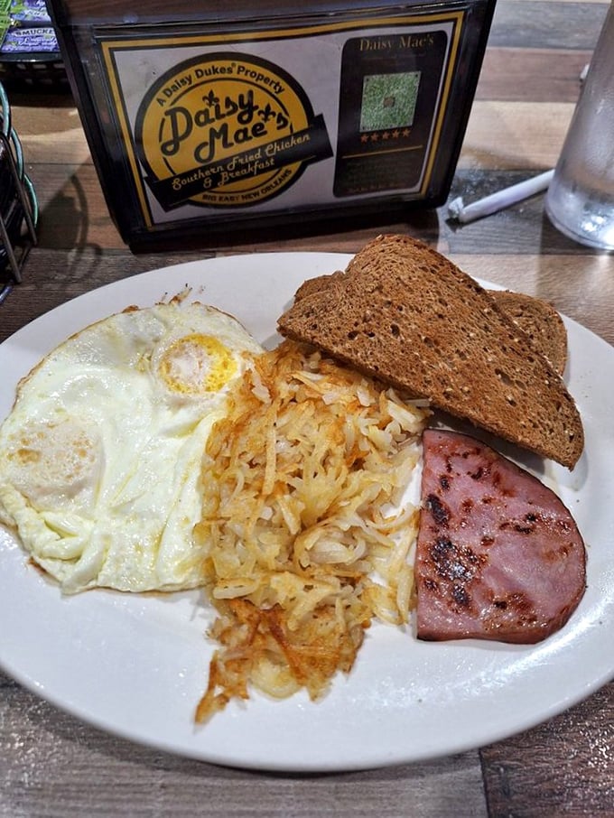 The breakfast trinity: perfectly fried eggs, crispy hash browns, and ham that didn't come from a package. Hallelujah!