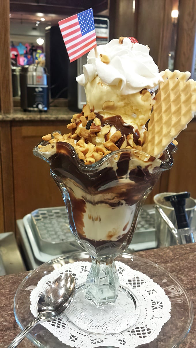 This patriotic sundae isn't just dessert—it's the American dream in a glass, complete with waffle cookie, hot fudge rivers, and a tiny flag claiming this mountain of deliciousness.