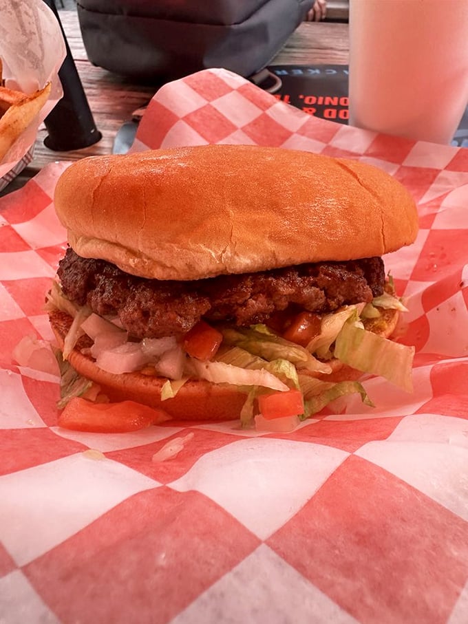 A burger built with purpose&mdash;fresh vegetables layered precisely beneath a perfectly seasoned patty on a toasted bun. Simplicity perfected.