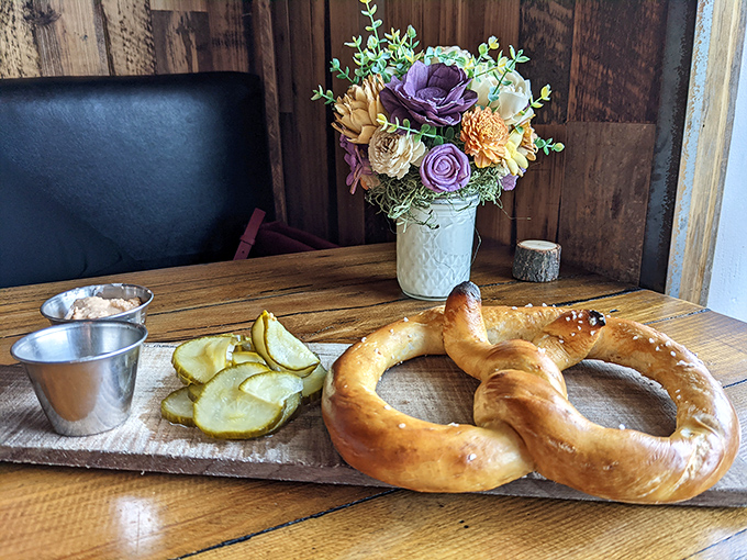 This isn't just a pretzel with pickles&mdash;it's edible architecture with a side of tang. The flower arrangement quietly judges your table manners.