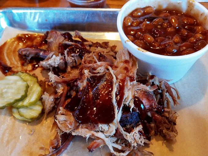 Pulled pork so tender it surrenders at the mere sight of a fork, accompanied by beans that have clearly been taking flavor lessons from the meat.
