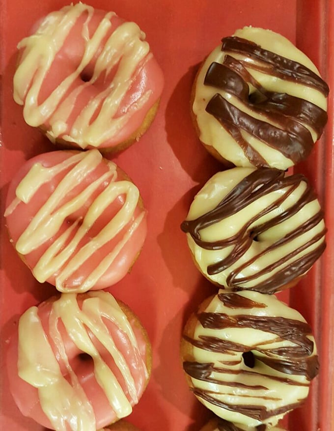 Long johns lined up like edible works of art. The chocolate ones whisper, "Diet tomorrow, paradise today." 