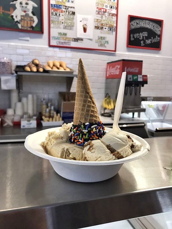Ice cream architecture at its finest&mdash;a waffle cone crown atop scoops adorned with rainbow sprinkles, proving some art is meant to be devoured.