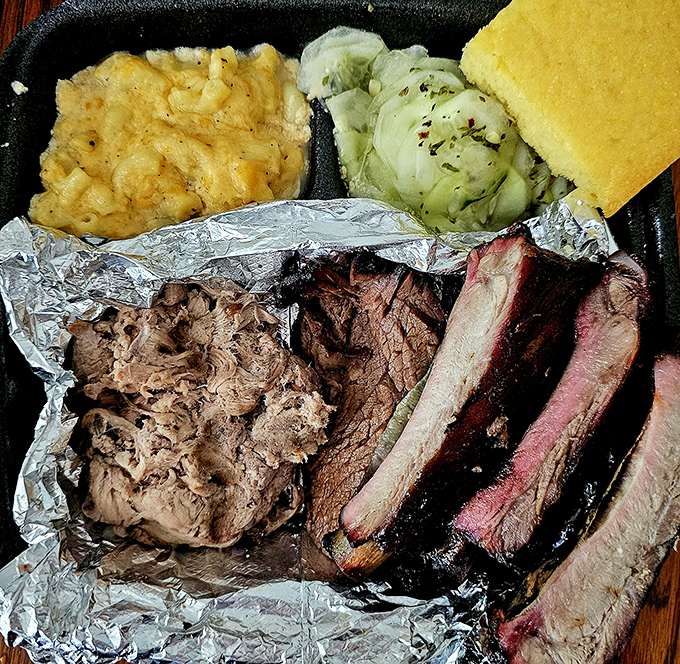 The holy trinity of barbecue&mdash;brisket, ribs, and pulled meat&mdash;sharing a plate with mac and cheese that demands equal attention.