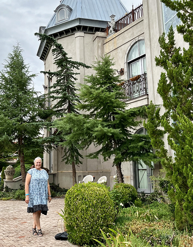 The castle's exterior provides a striking backdrop for visitors, with its cream-colored walls and lush landscaping creating an unexpected oasis in the desert.