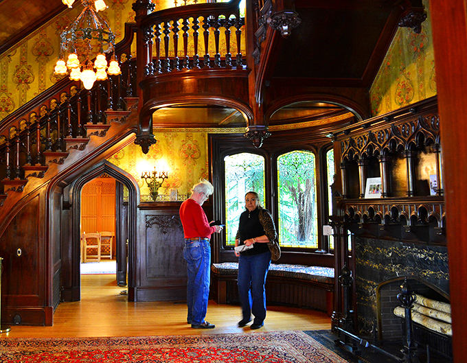 The grand staircase isn't just functional&mdash;it's architectural theater. Those rich wood tones and yellow wallcoverings create warmth that modern homes can only dream about.