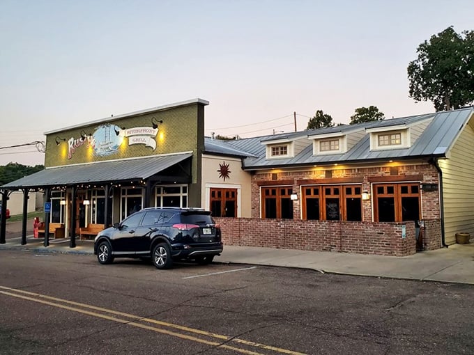Rusty's illuminated storefront beckons hungry travelers with the promise of riverfront dining and perfect cuts.