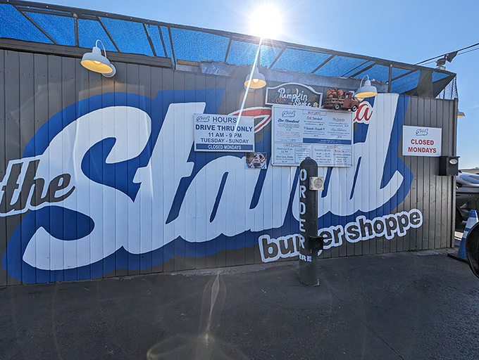 The Stand's bold blue exterior announces its burger confidence. This tiny drive-thru spot proves that sometimes less menu means more flavor.