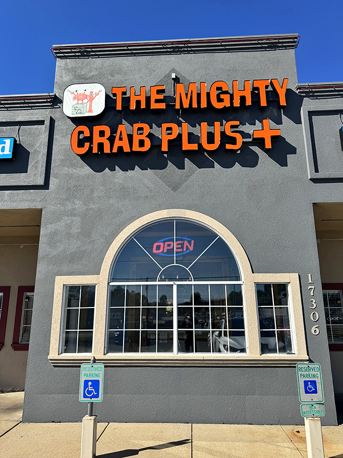 Bold orange letters against gray concrete - The Mighty Crab doesn't need fancy architecture when the seafood inside speaks volumes.