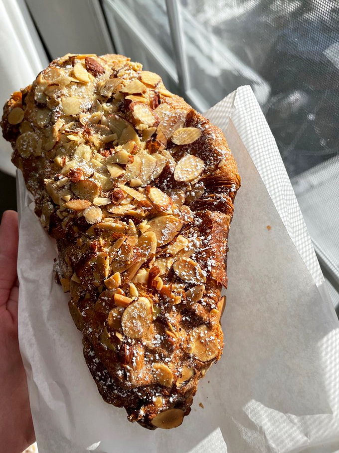 The almond croissant up close reveals its true glory&mdash;a burnished exterior giving way to buttery layers and sweet almond filling. Resistance is futile.