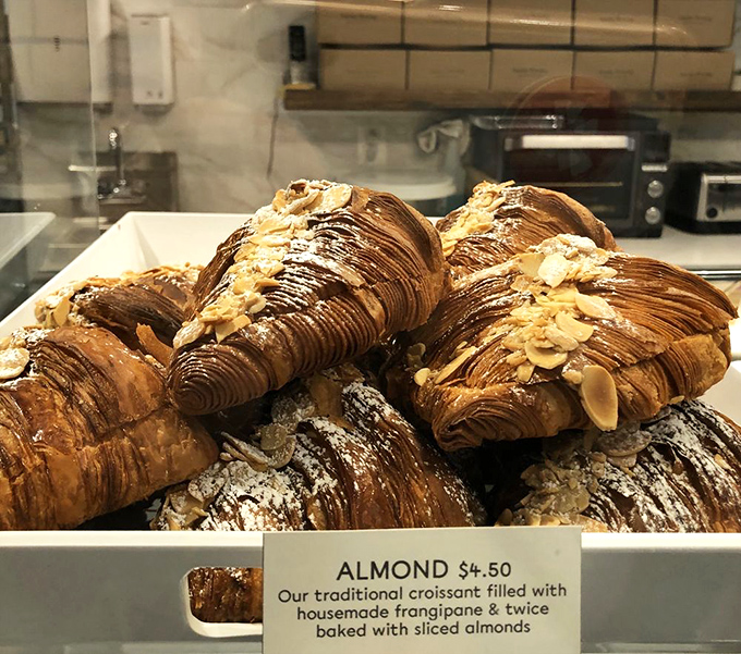 Almond croissants dusted with powdered sugar and topped with sliced almonds—architectural marvels that French engineers would applaud.