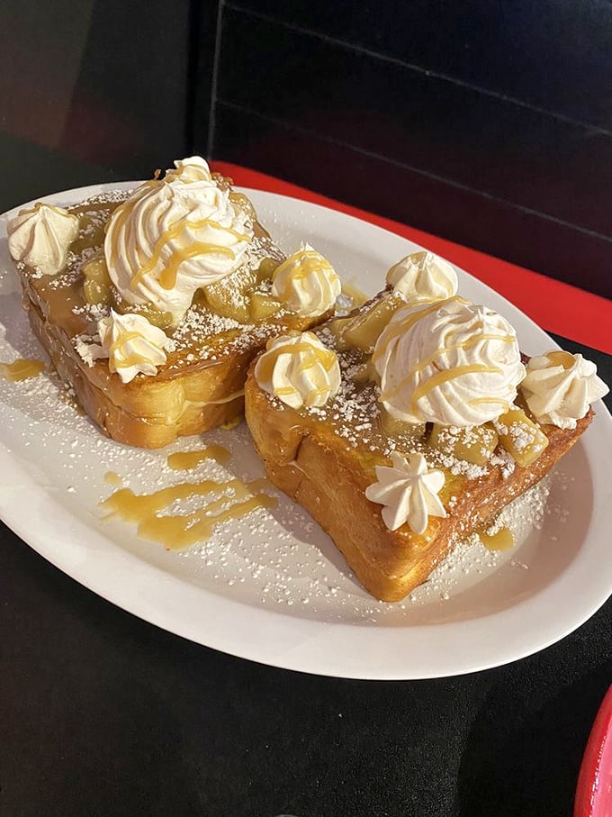 French toast architecture at its finest – golden slices supporting whipped cream peaks and caramel valleys. Breakfast or dessert? Yes.