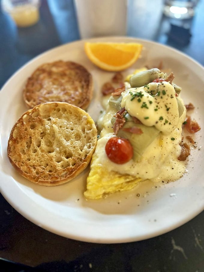 Hollandaise cascading over eggs like a golden waterfall, with English muffins standing by, ready to soak up every last drop of heaven.