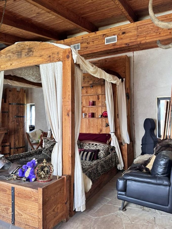 A royal bedroom fit for medieval nobility, complete with canopy bed and modern leather chair. Even knights need somewhere comfy to kick off their armor.