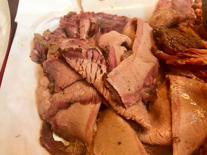 The perfect brisket reveals itself in that telltale smoke ring and bark that crackles with flavor. This plate is why people drive across state lines without hesitation.