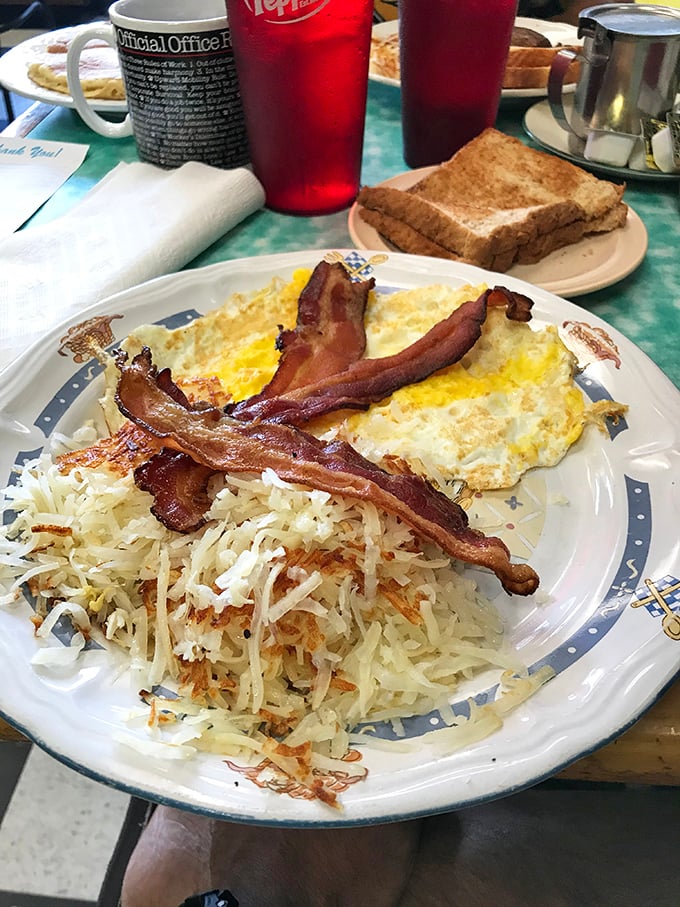 Breakfast artistry at its finest. The bacon curves like it's posing for a food magazine, while the hash browns spread out in golden glory.
