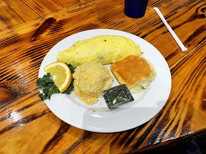 Breakfast platter perfection: where the omelet, home fries, and biscuit form a triumvirate of morning magnificence.