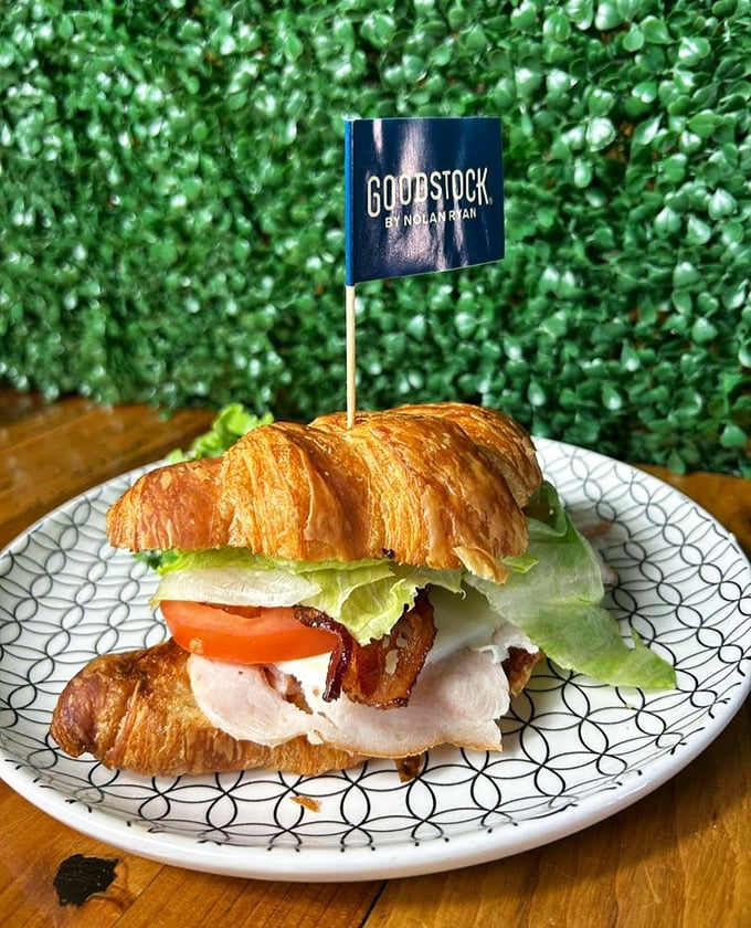 The "Goodstock" croissant sandwich brings together turkey, bacon, and fresh veggies in what can only be described as breakfast architecture.