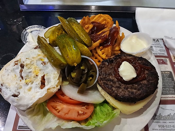 The bacon cheeseburger arrives like a savory skyscraper, surrounded by a golden forest of hand-cut fries. This is why elastic waistbands were invented.