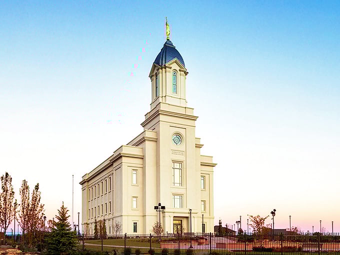 The Cedar City Utah Temple stands as a serene architectural counterpoint to downtown's bustling antique scene, its clean lines gleaming in the sunset light.
