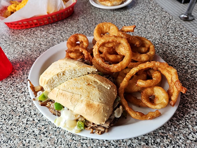 That cheesesteak sandwich paired with golden onion rings delivers serious comfort food credentials to your table.