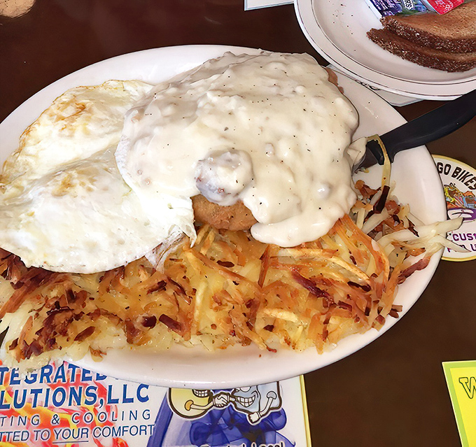 This isn't just breakfast &ndash; it's edible architecture. Crispy-edged chicken fried steak supporting a sunny egg with hash browns as the foundation.
