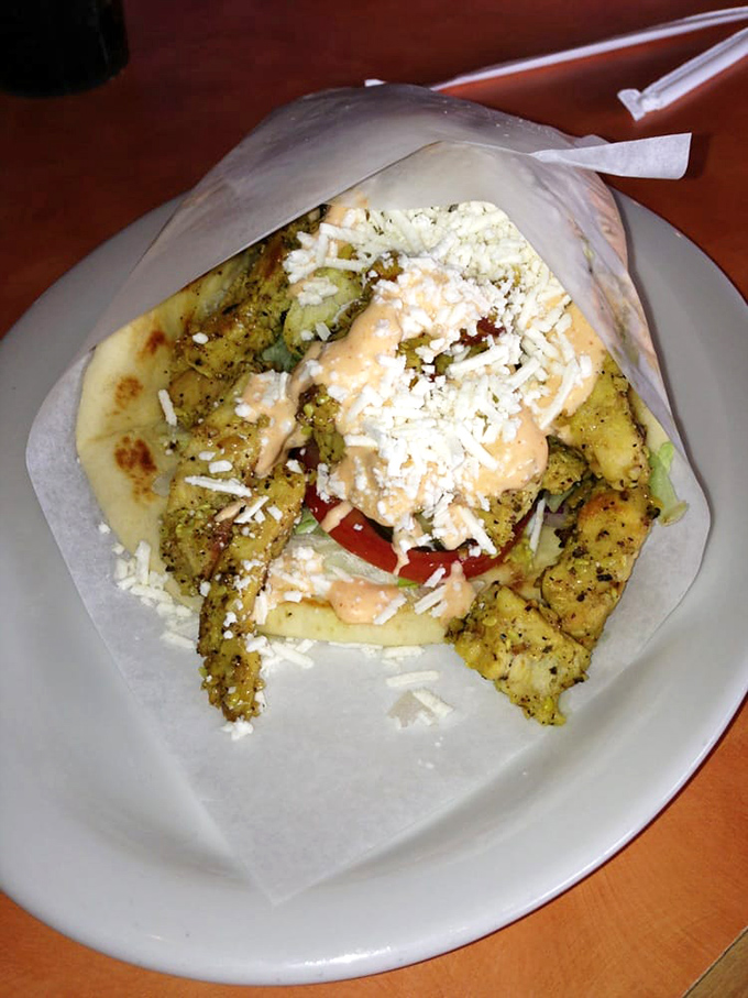 Chicken gyro perfection: herb-marinated meat, garden-fresh veggies, and that sauce&mdash;oh that sauce!&mdash;coming together in pillowy pita perfection.