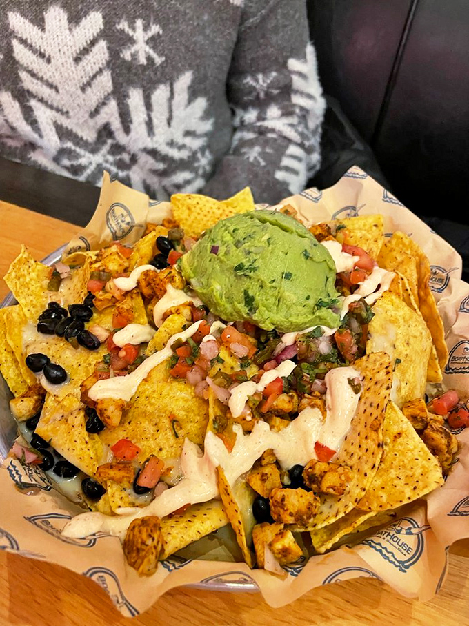 Nachos elevated to an art form – a mountain of chips supporting guacamole, black beans, and enough cheese to make Wisconsin nervous.