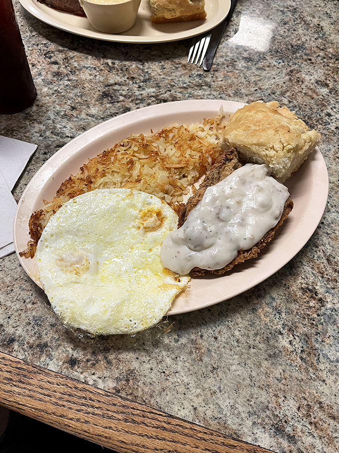 Breakfast nirvana achieved: country fried steak with gravy, perfectly cooked eggs, and hash browns that strike the ideal balance between crispy and tender.