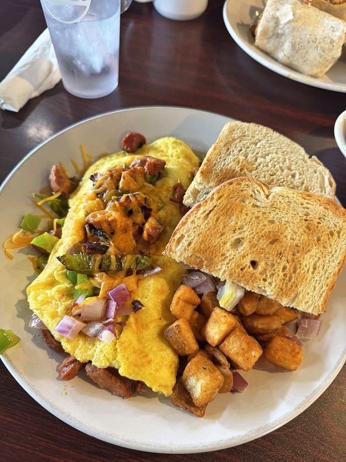This isn't just an omelet&mdash;it's a masterpiece of morning architecture with sausage, peppers, and onions tucked into fluffy egg perfection.