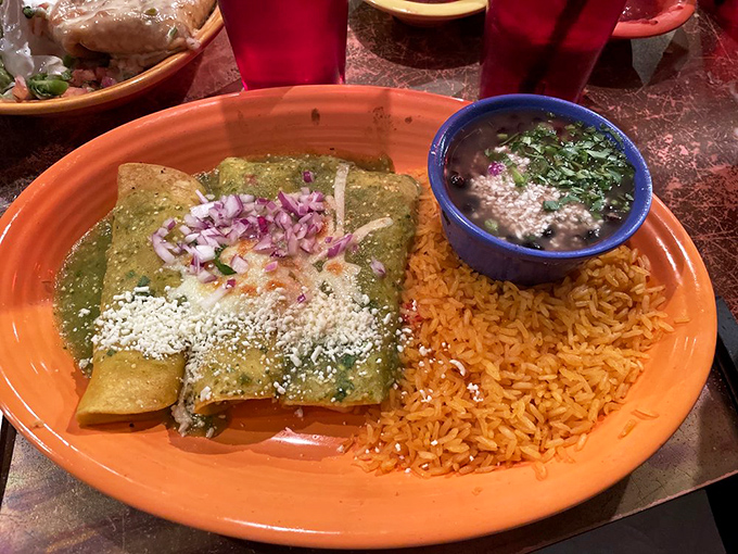 Seafood in Kansas? These camarones enchiladas prove landlocked states can nail ocean flavors. Green sauce and Spanish rice make the perfect maritime escort.