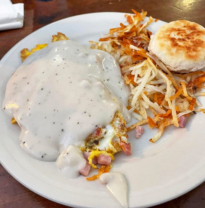 Morning magic on a plate: a fluffy omelet draped in gravy, paired with a golden pancake. The kind of breakfast that makes you forgive Monday for being Monday.