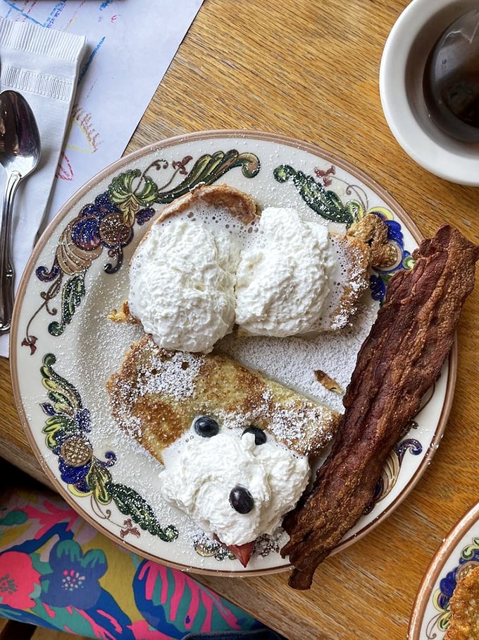 The breakfast trifecta: French toast, fresh fruit, and whipped cream, with a side of bacon that could make a vegetarian reconsider their life choices.