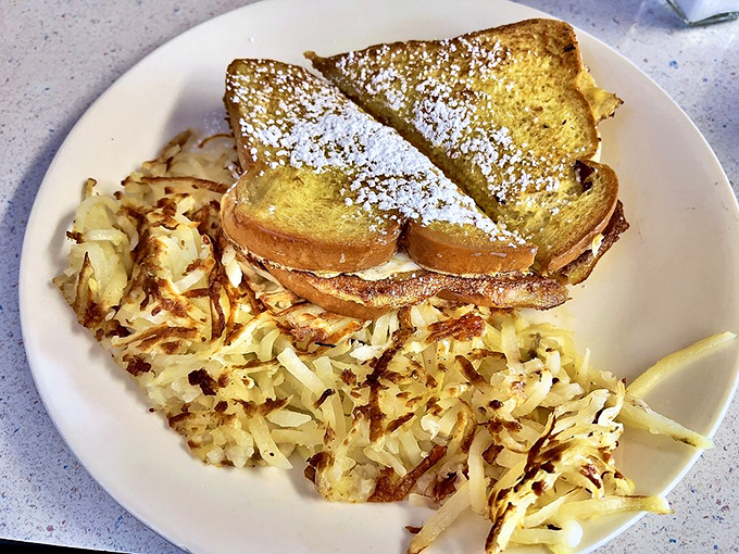 French toast that's achieved the perfect balance of crispy exterior and custardy interior, with hash browns that could make a potato weep with pride.