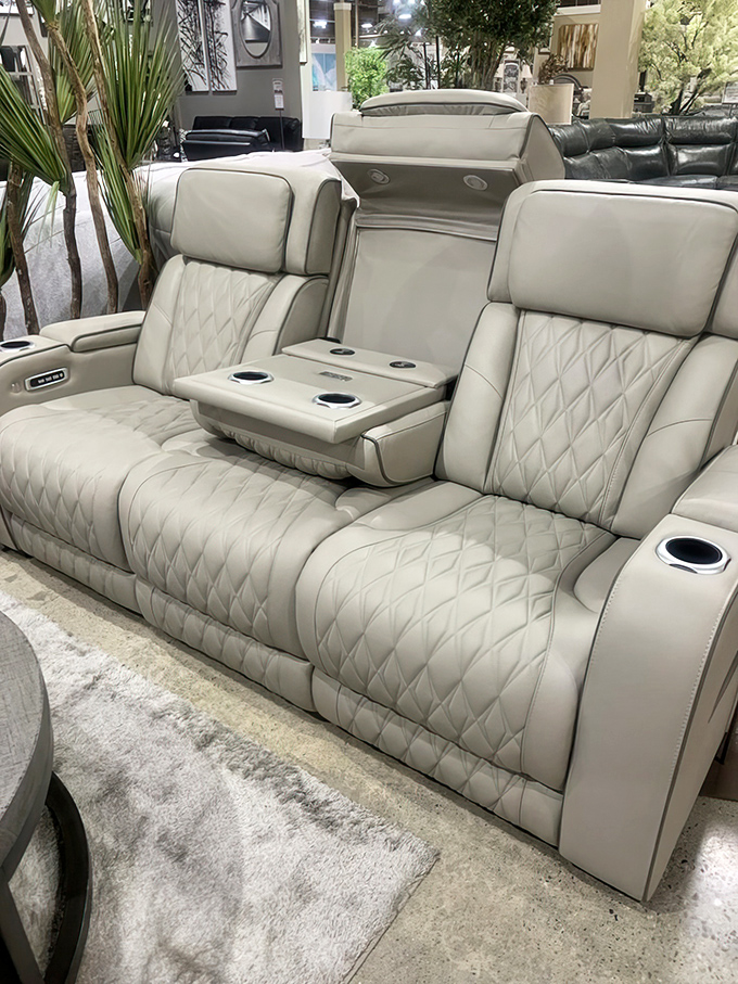 This isn't just a leather sectional—it's a quilted command center with cup holders that could organize your entire beverage history for the day.