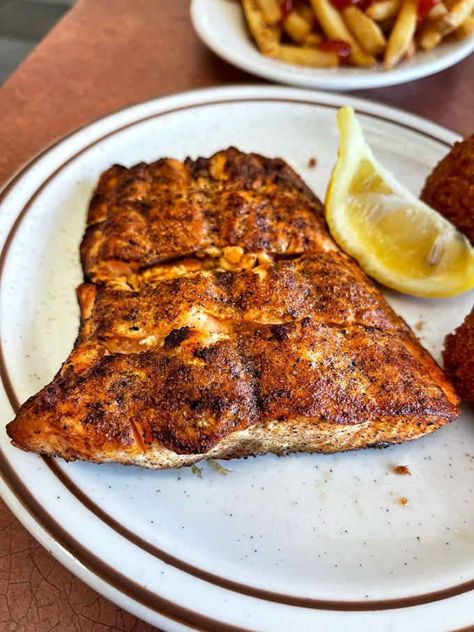 Salmon with a suntan! This perfectly grilled fillet wears its seasoning like a badge of honor, flaking at the mere suggestion of a fork.