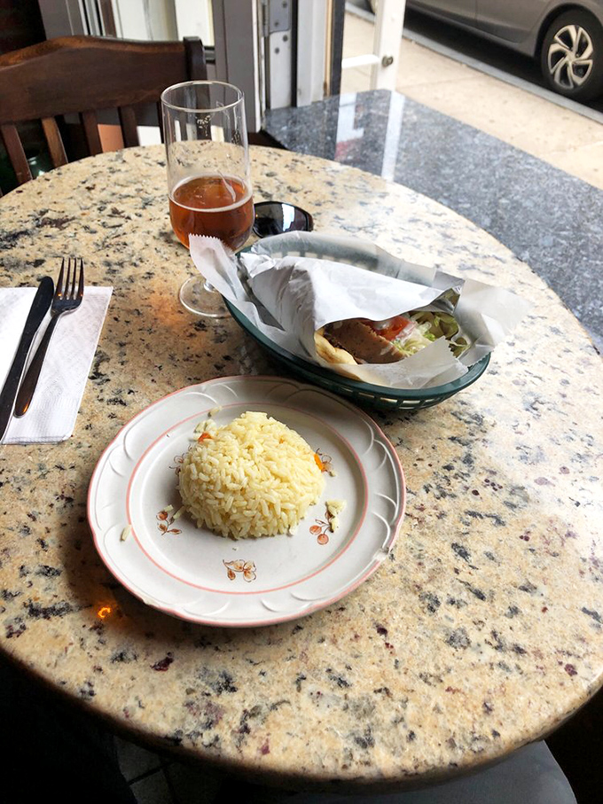 A study in delicious contrasts: fluffy rice, savory gyro meat, and a cold beer. This isn't just lunch &ndash; it's a Mediterranean vacation on a plate.