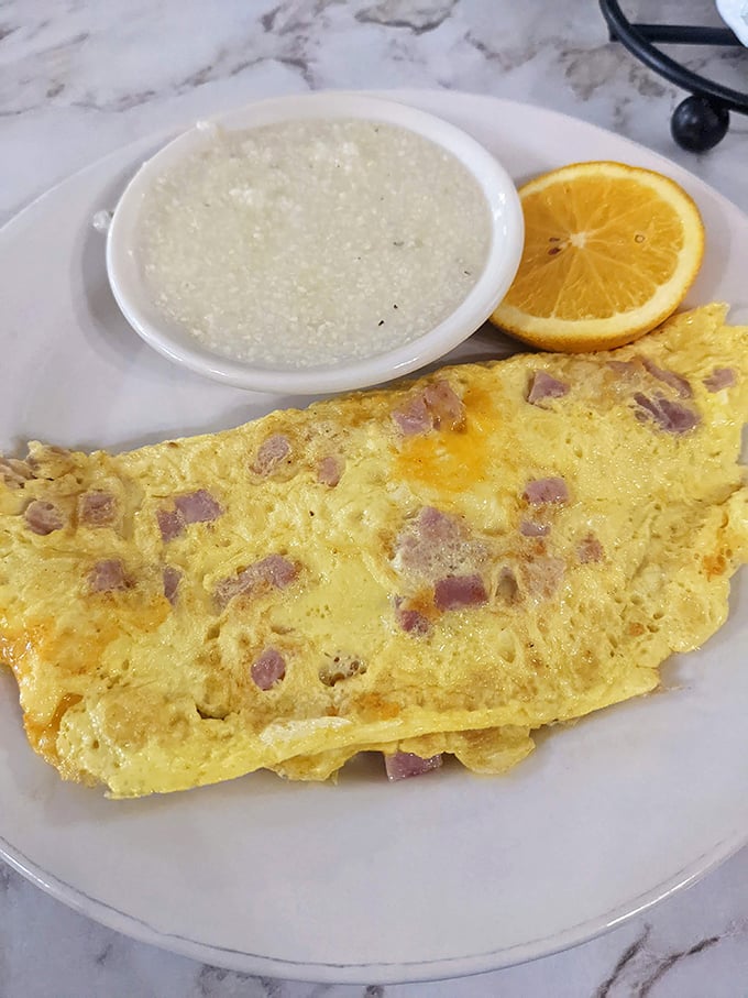 This omelet doesn't need fancy ingredients to impress—just perfect execution, generous ham chunks, and creamy grits that taste like Southern sunshine.
