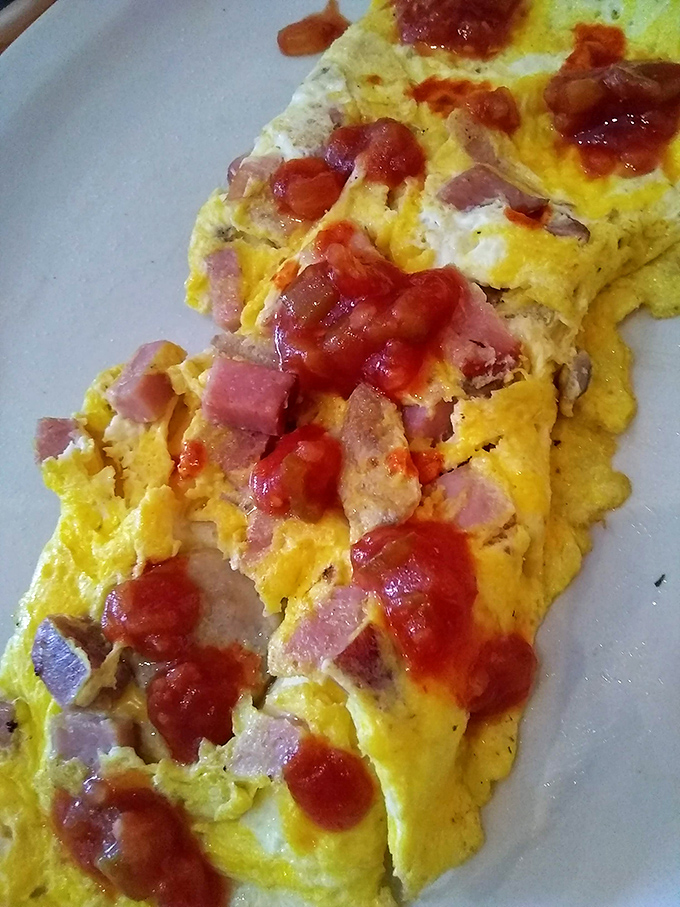 Ham and eggs perform their timeless breakfast ballet, with splashes of salsa adding just enough kick to wake up your taste buds.