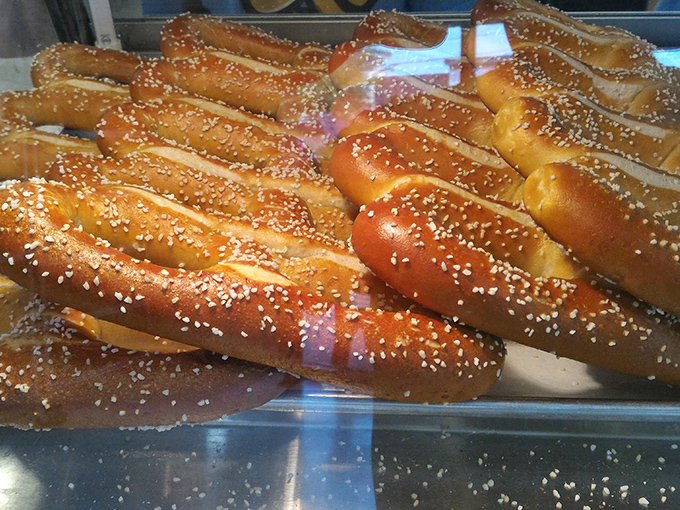 Fresh pretzels lined up like edible sculptures, their golden-brown curves glistening with salt. The Sistine Chapel of snack food.