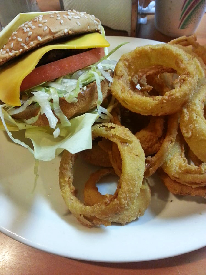 Golden onion rings that crunch like autumn leaves, paired with a cheeseburger that reminds you why fast food chains are just playing pretend.