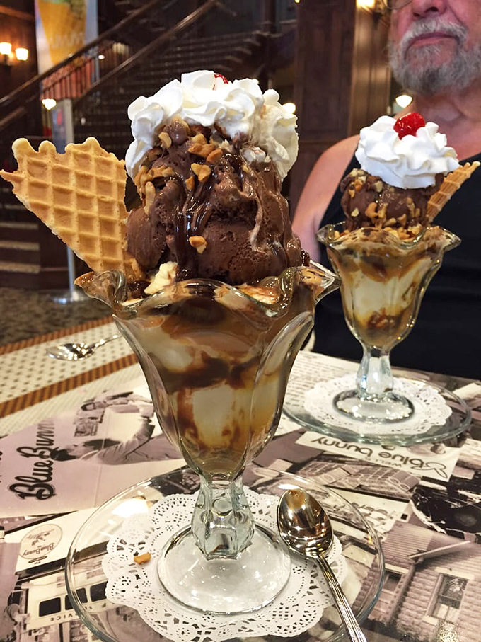 Chocolate ice cream architecture at its finest—layers of fudge and toppings creating a dessert that's one part indulgence, two parts structural engineering marvel.